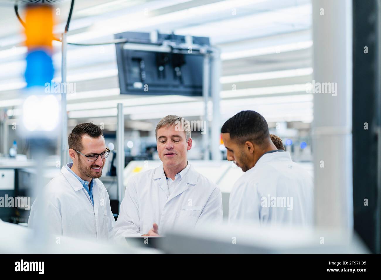 Technicians in lab coats discussing in electronics factory Stock Photo ...