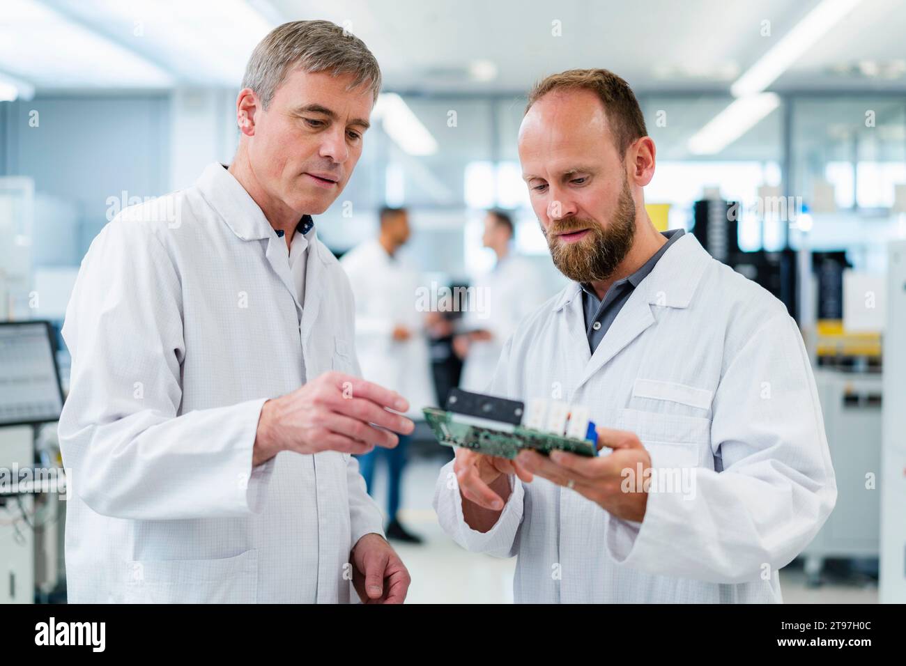 Colleagues in electronics factory discussing over motherboard Stock ...