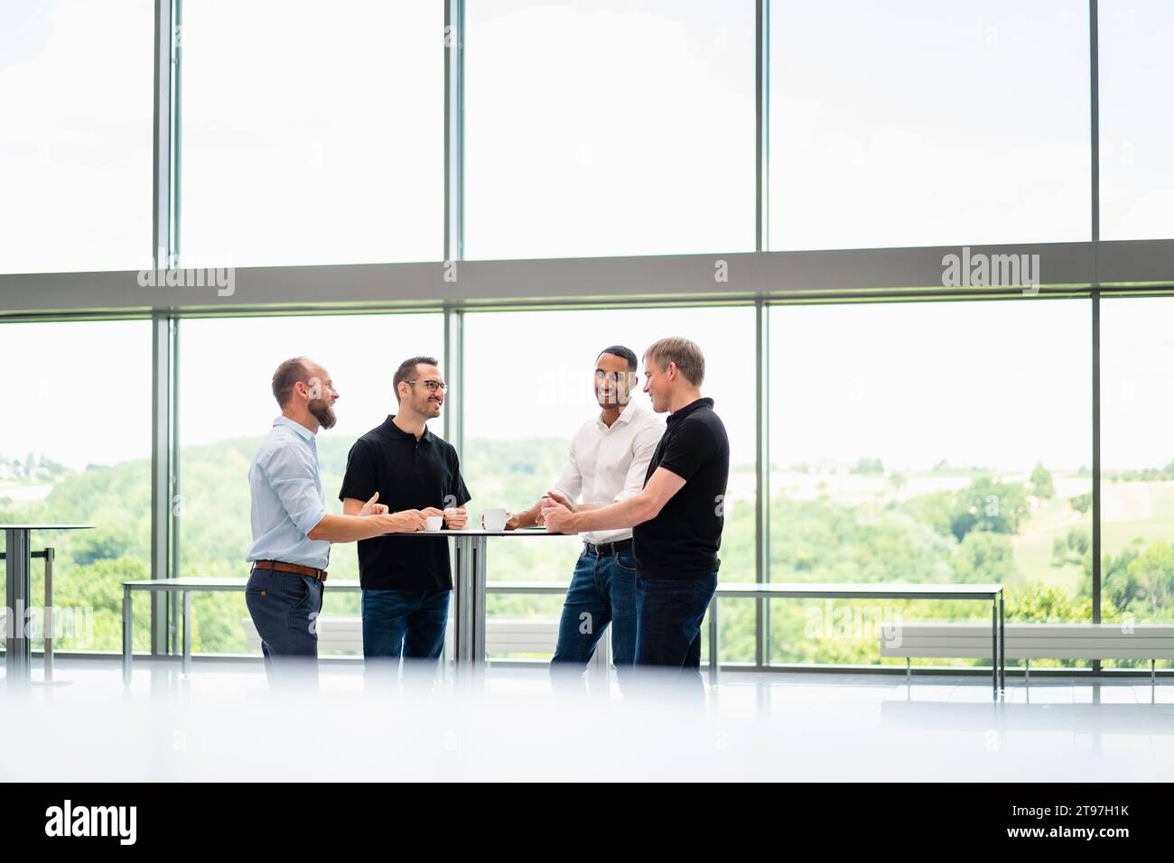 Group of businessman having informal meeting standing in office hall ...