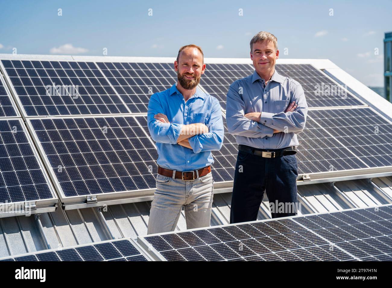 Two businessmen exude confidence as they stand among rows of solar ...