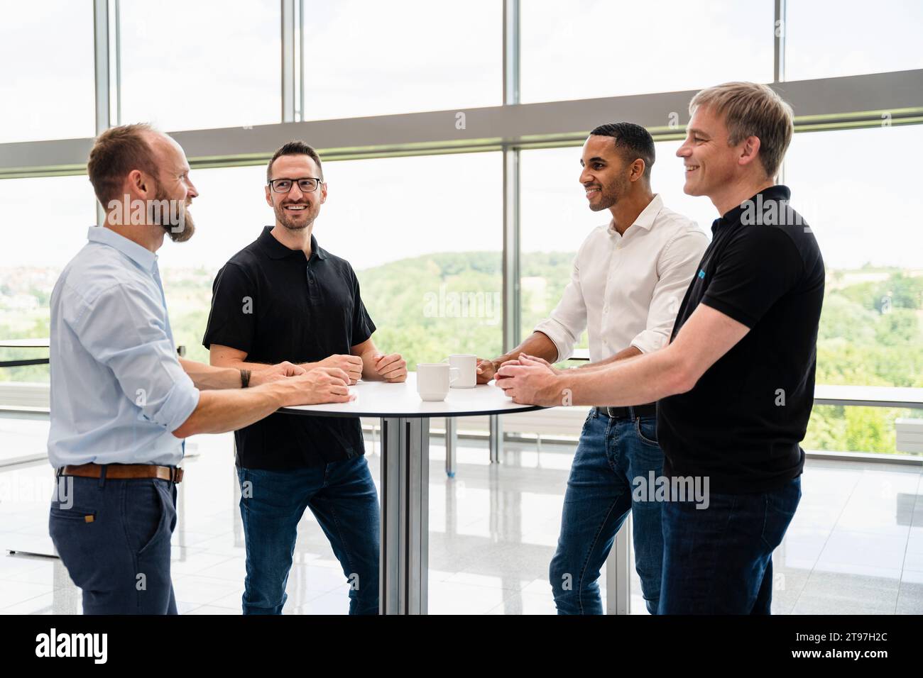 Group of businessman having informal meeting standing in office hall ...