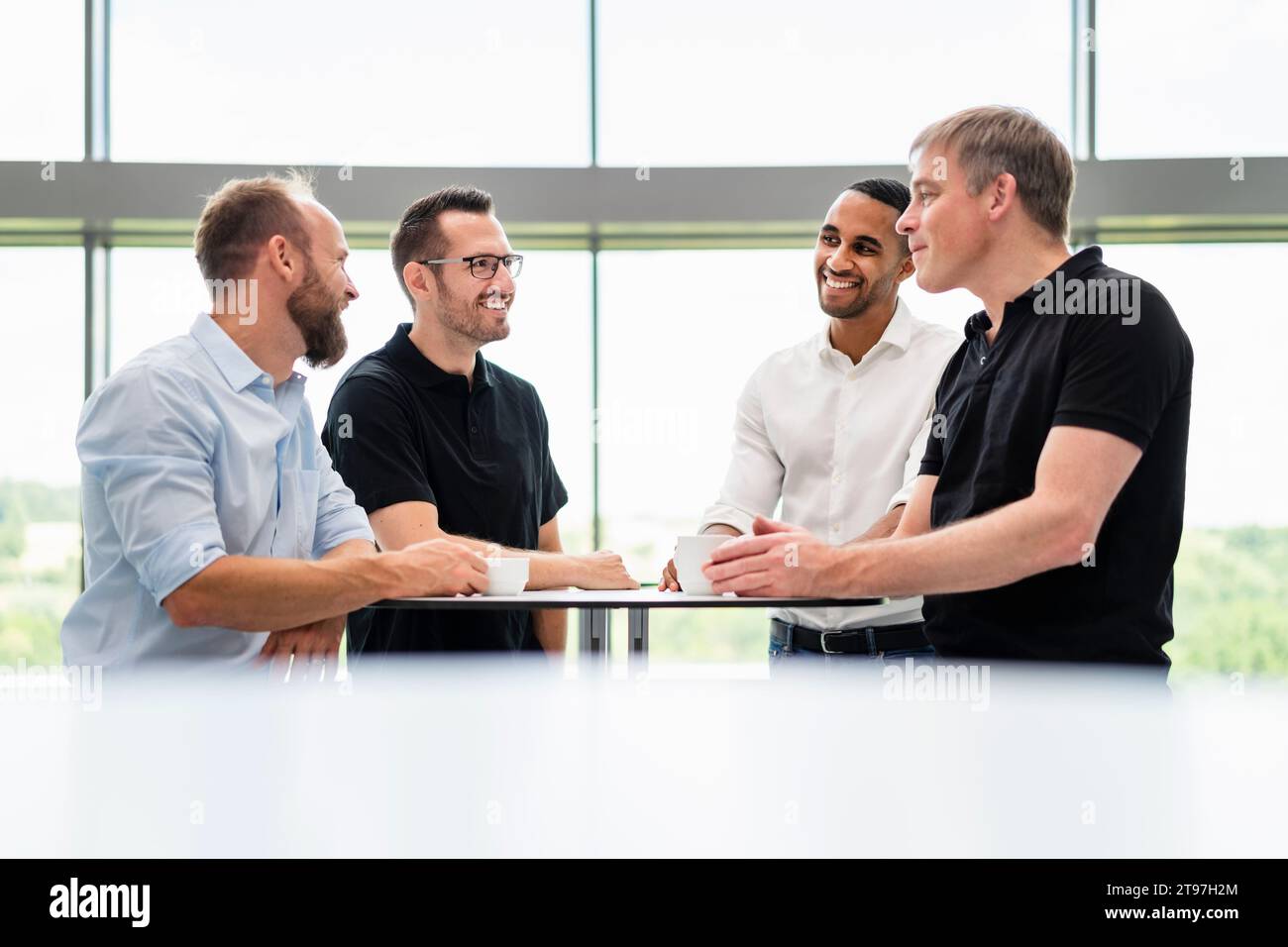 Group of businessman having informal meeting standing in office hall ...