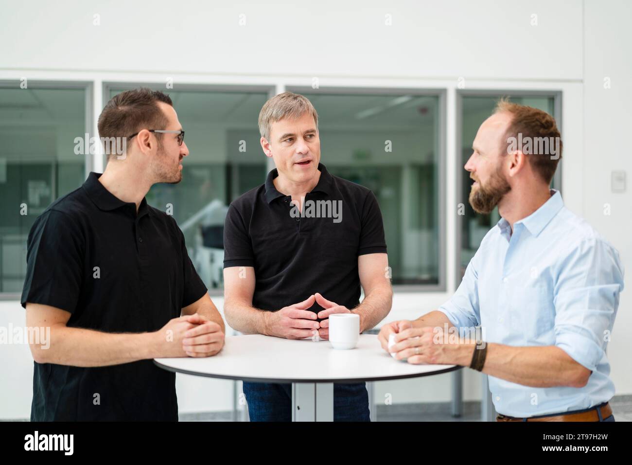 Group of businessman having informal meeting standing in office hall ...