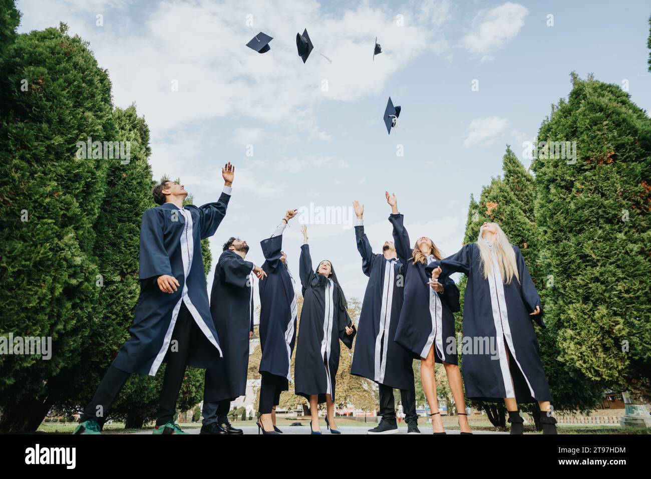 University students throwing their caps in the air, creating beautiful ...
