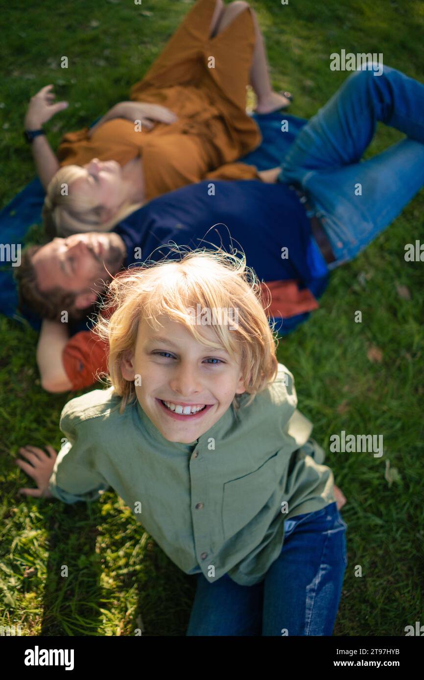 Smiling boy with parents relaxing on grass Stock Photo - Alamy