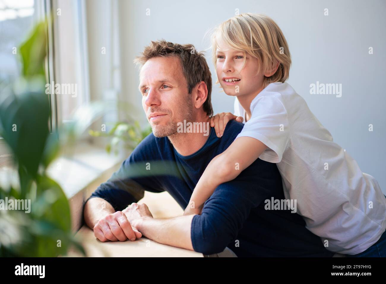 Thoughtful father and son in front of white wall at home Stock Photo ...