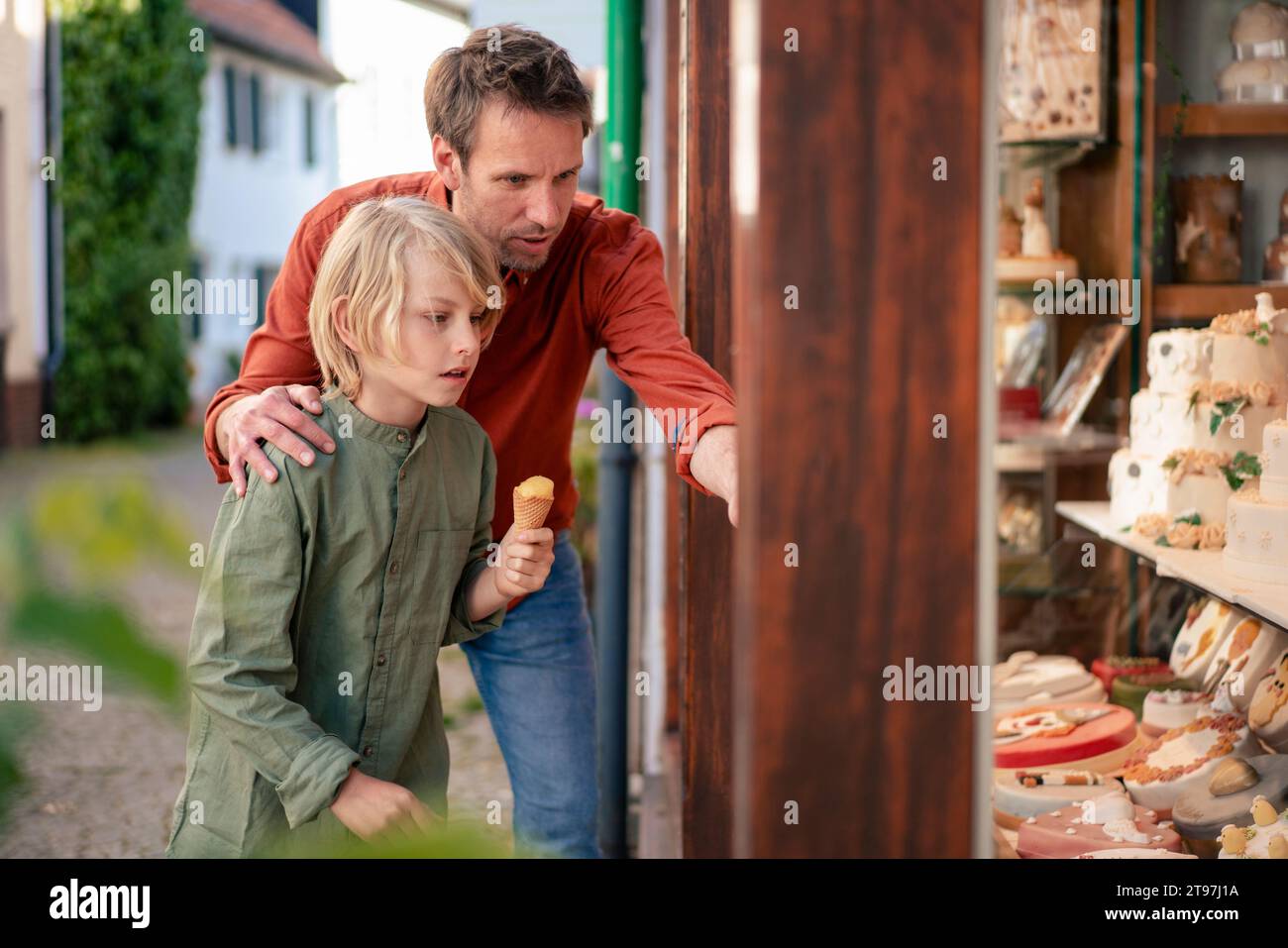 Father showing cakes to son near bakery Stock Photo - Alamy
