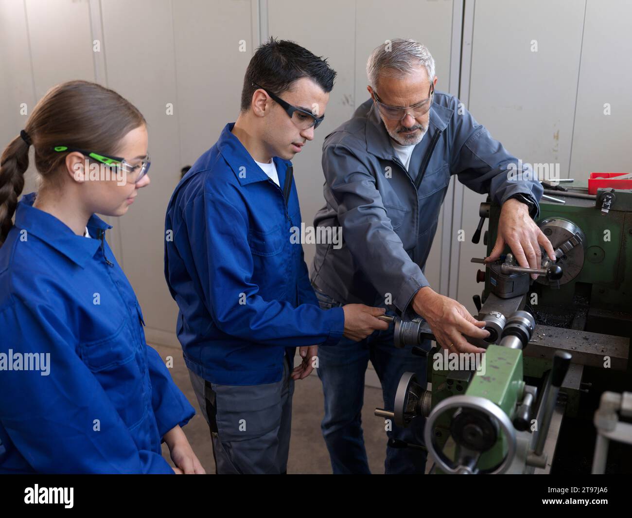 Instructor guiding apprentices using lathe at workshop Stock Photo - Alamy Instructor guiding apprentices using lathe at workshop Stock Photo - Alamy