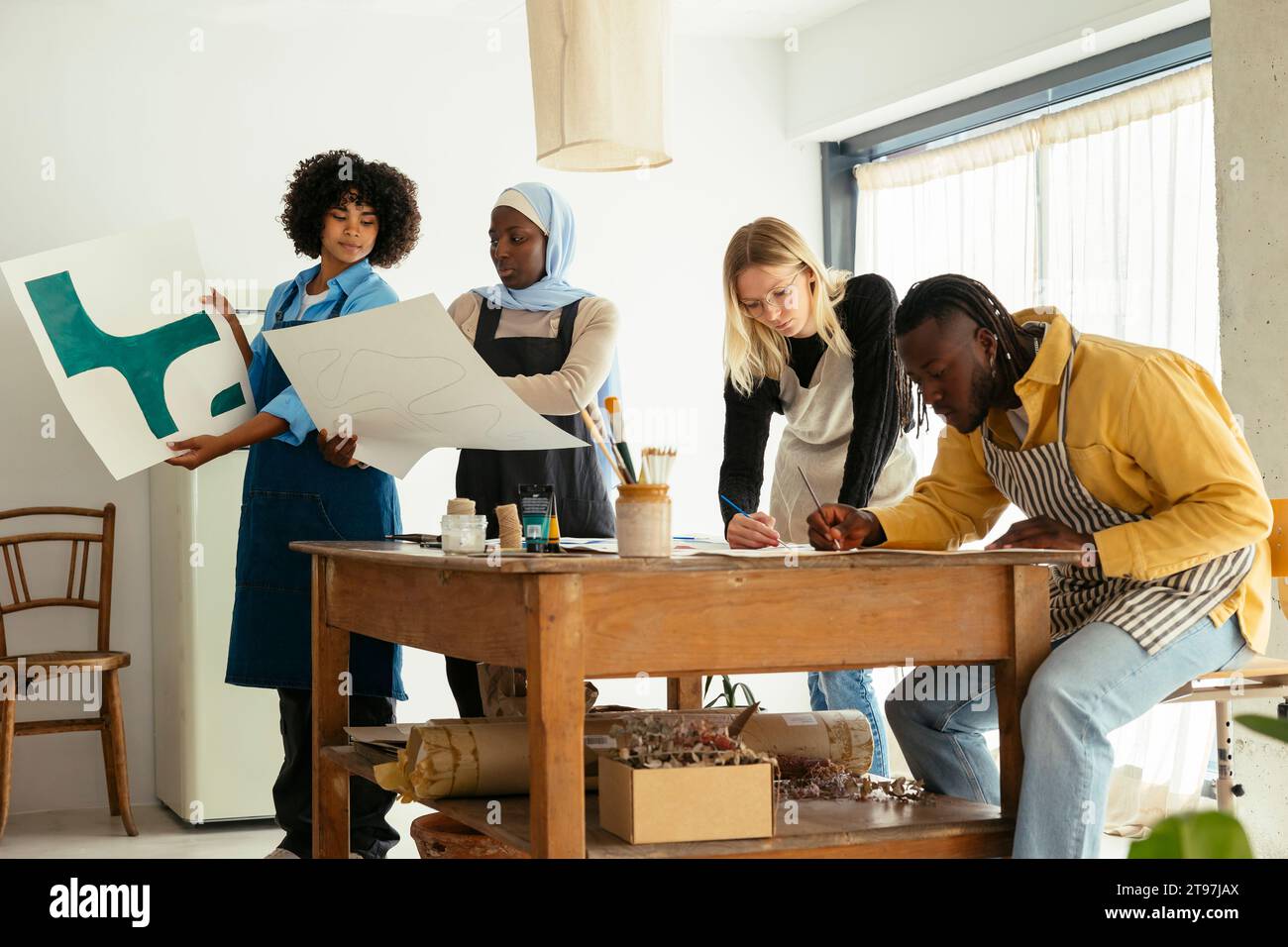 Artists working with paintings in studio Stock Photo - Alamy