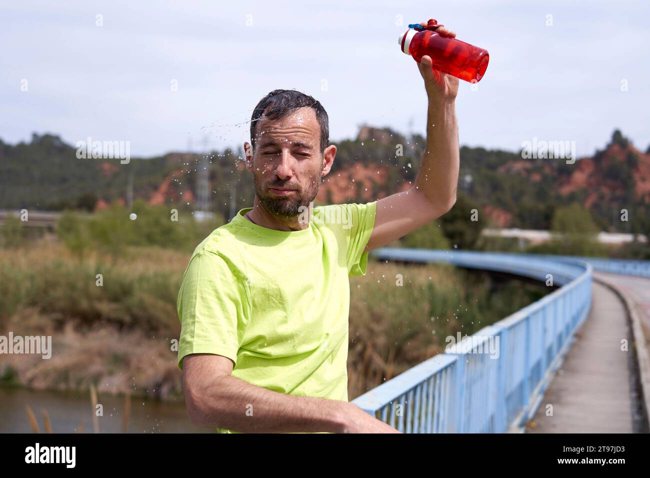 Man splashing water on face through bottle Stock Photo - Alamy
