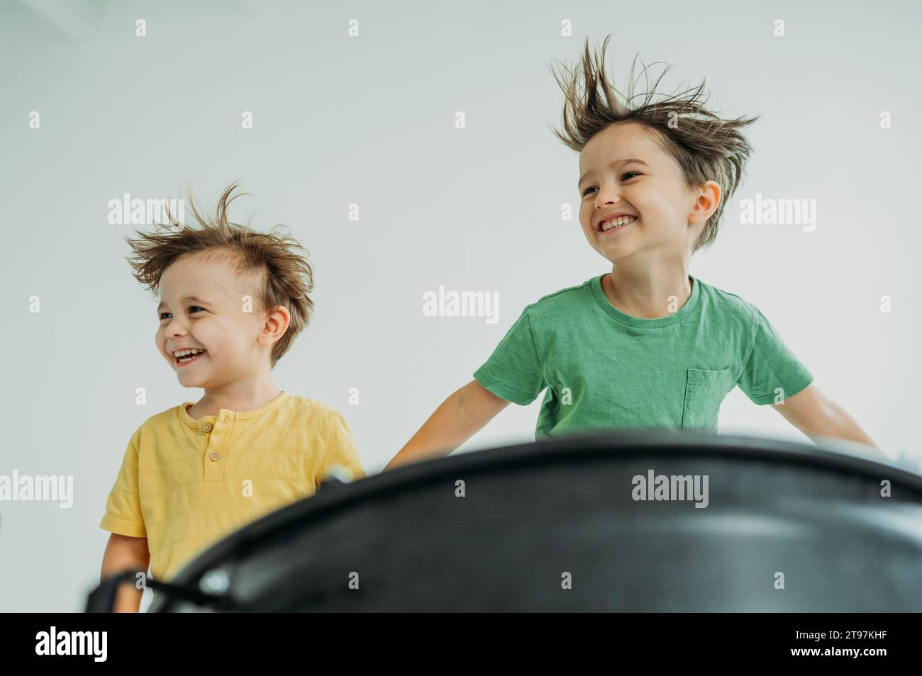 Happy children having fun in front of white wall Stock Photo - Alamy