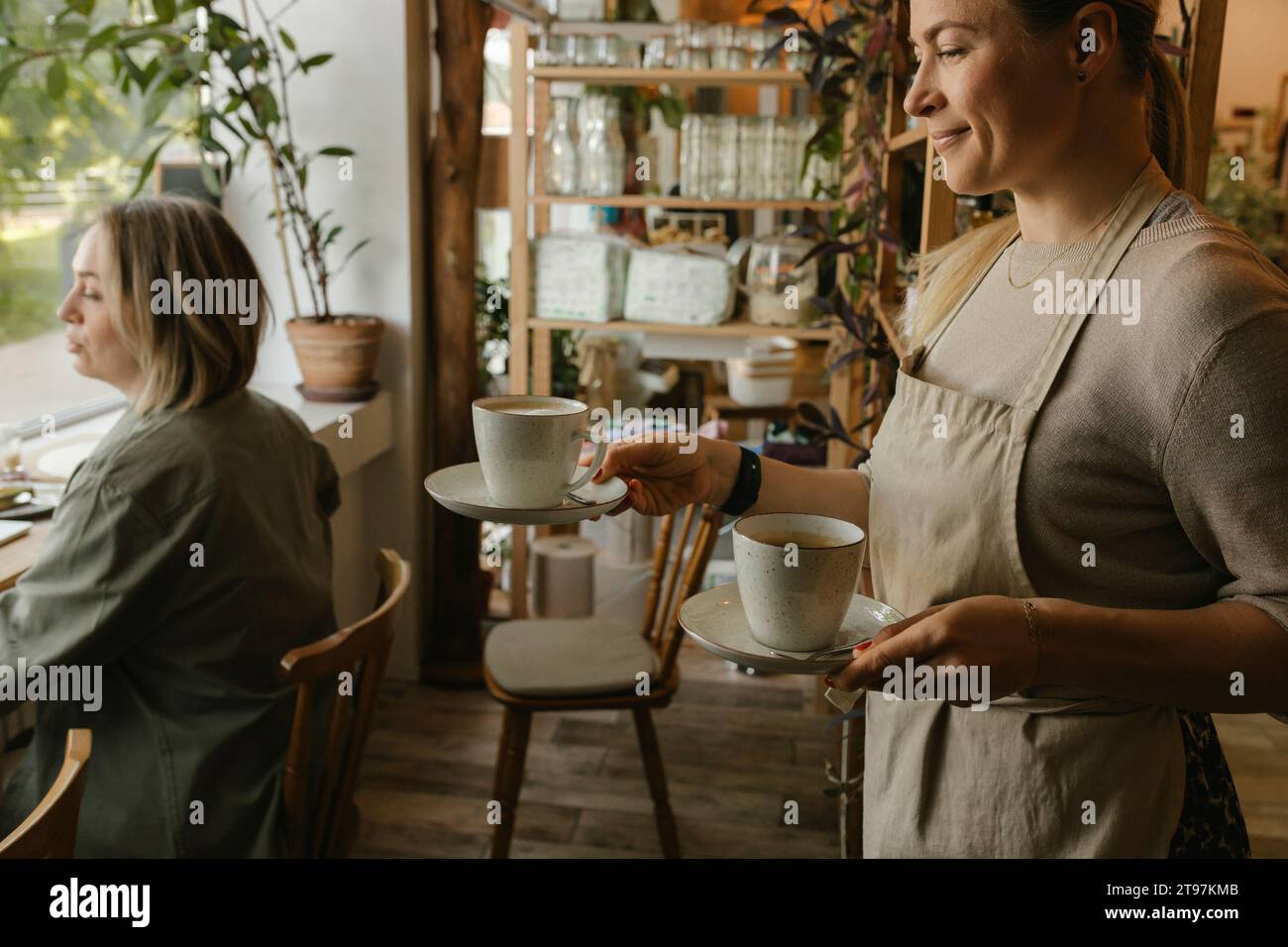 Smiling waiter serving coffee to customer in cafe Stock Photo - Alamy