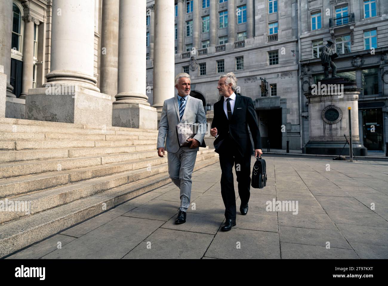Businessmen walking together near financial buildings Stock Photo - Alamy
