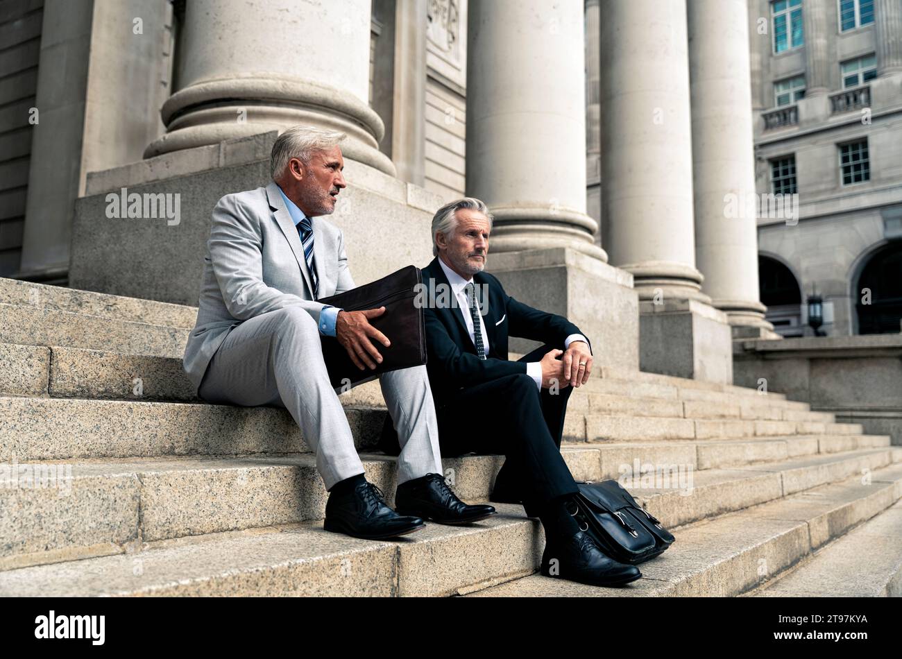 Senior businessmen sitting together on steps Stock Photo - Alamy