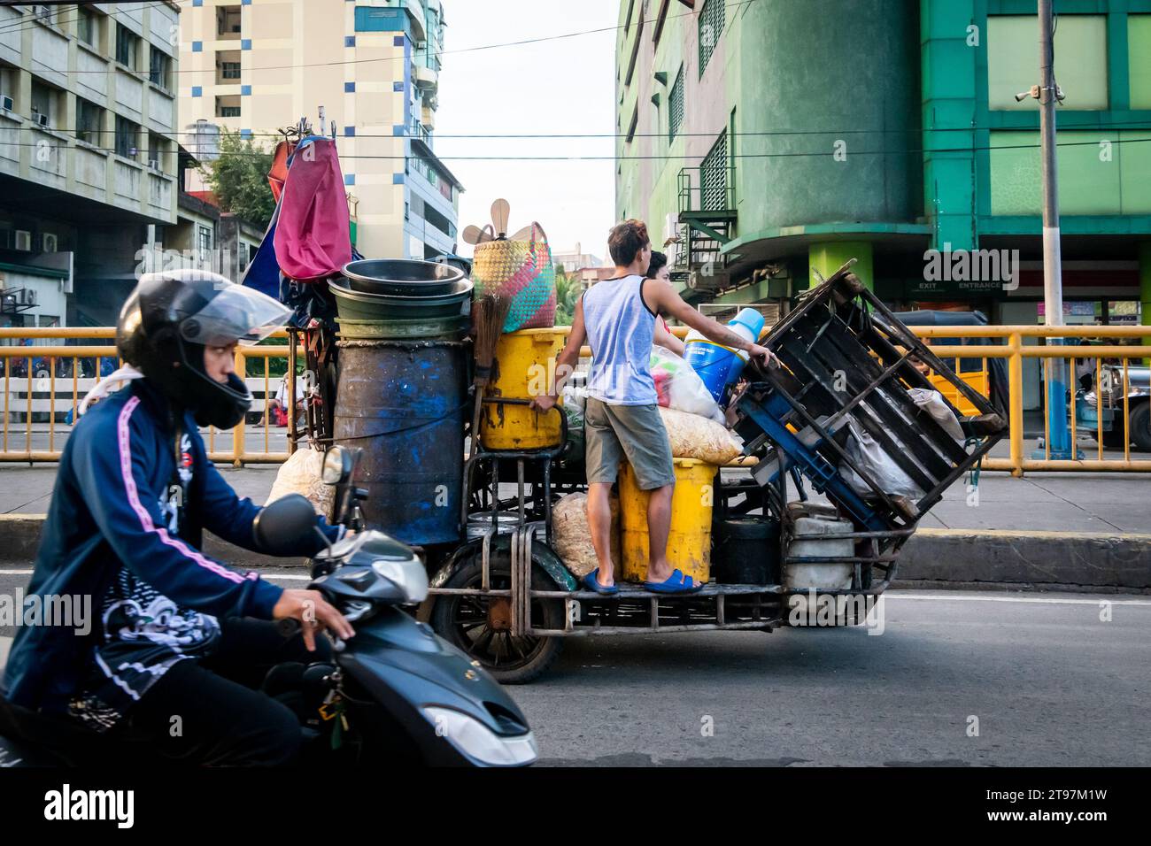 Some Filipino workers make a delivery of goods on a strange tractor ...