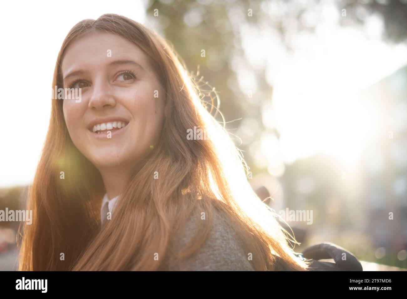 Happy young woman with long hair in sunlight Stock Photo - Alamy