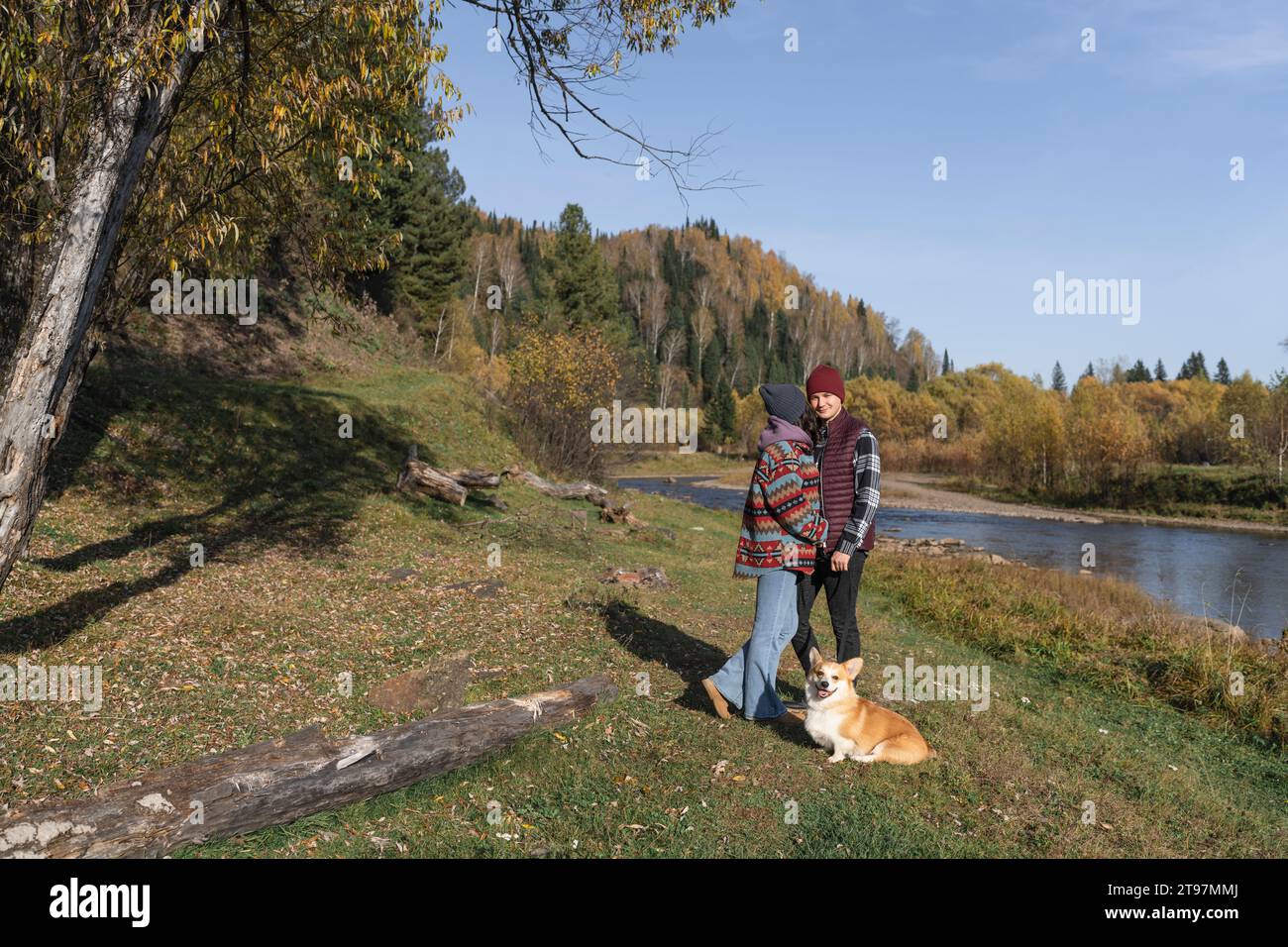 Couple embracing by Pembroke welsh corgi in nature park Stock Photo - Alamy