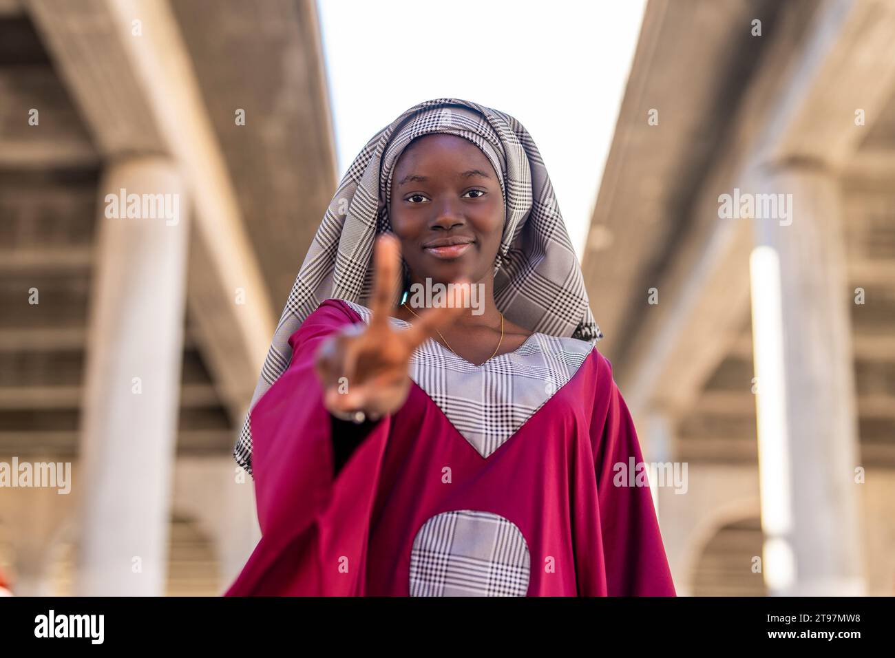 Young woman with hijab gesturing peace sign Stock Photo - Alamy
