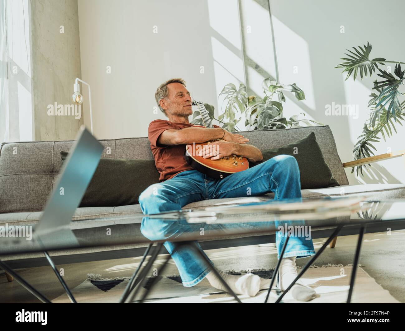 Man sitting home on sofa hi-res stock photography and images - Alamy