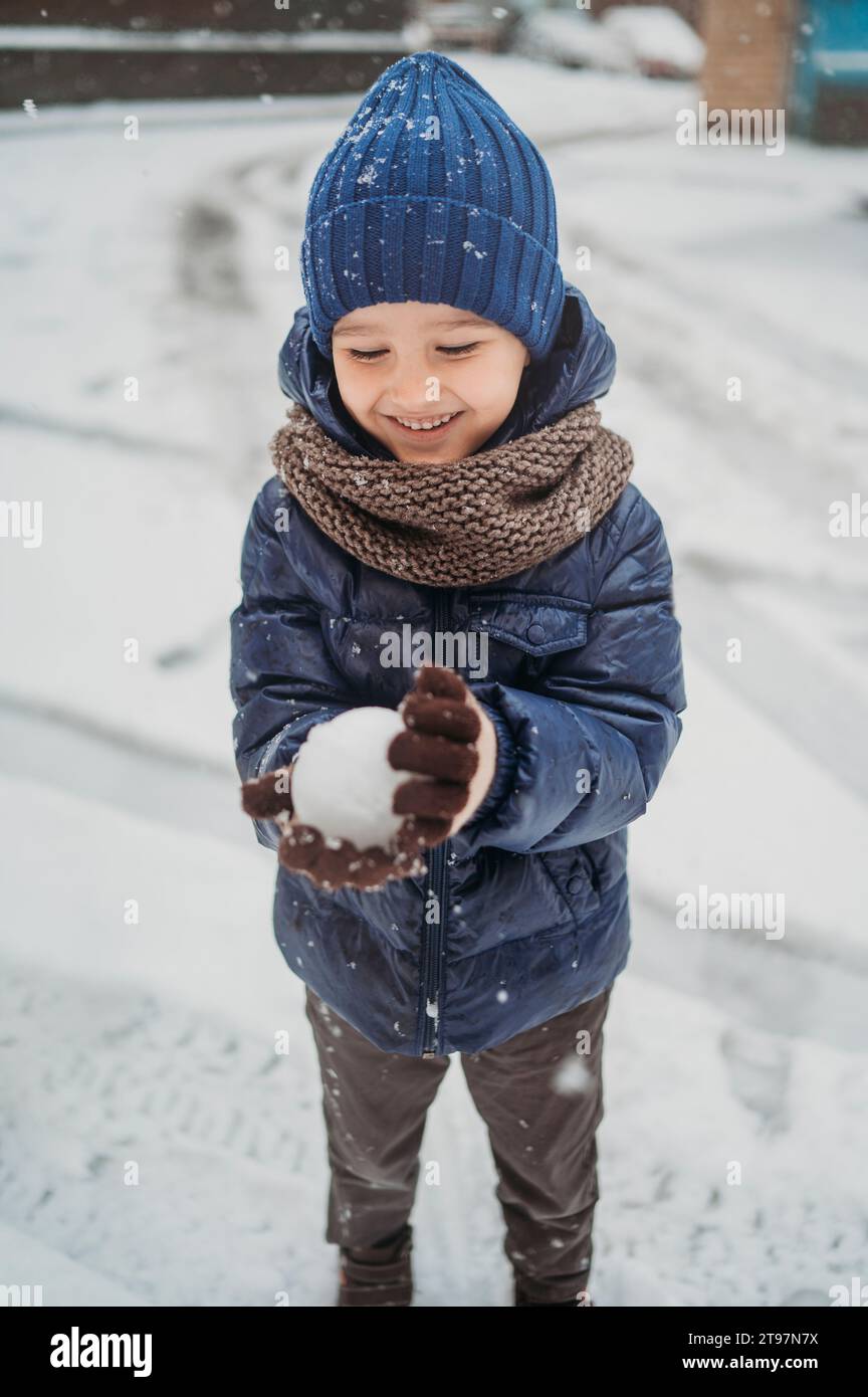 Boy making snowball smiling hi-res stock photography and images - Alamy