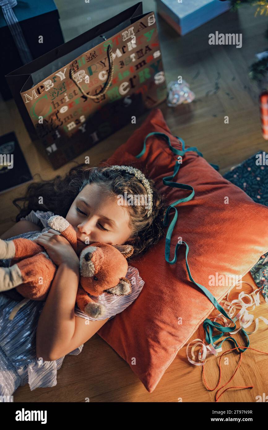 Girl sleeping on cushion and hugging stuffed toy at home Stock Photo ...