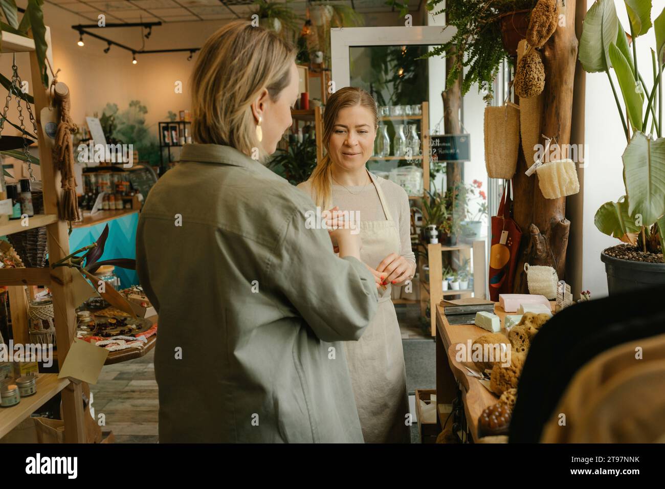 Woman helping customer to shop in zero waste store Stock Photo - Alamy
