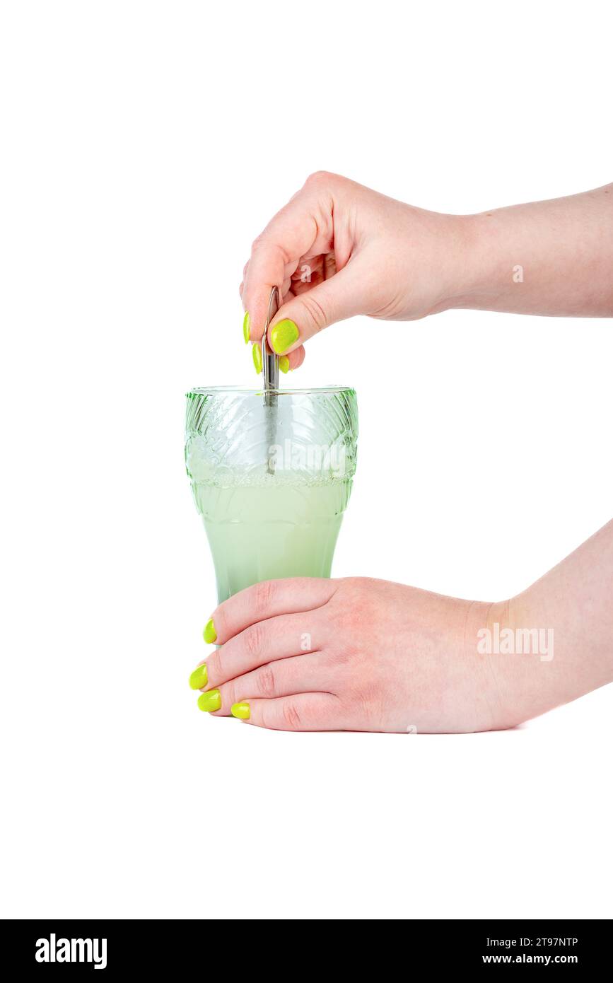 Woman mixing powdered medicine or protein in a glass of water on a ...