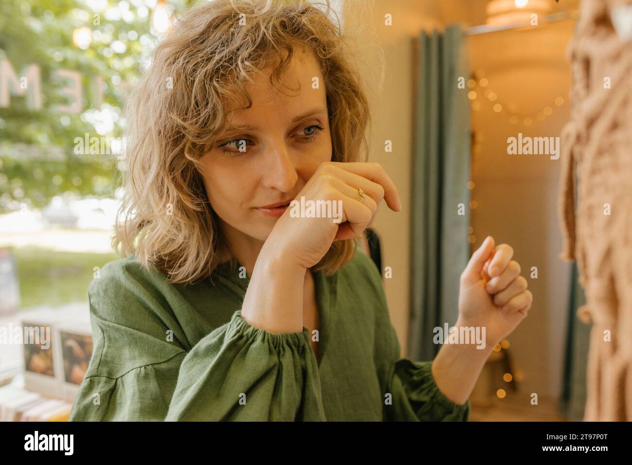Blond woman smelling perfume on hand in store Stock Photo - Alamy