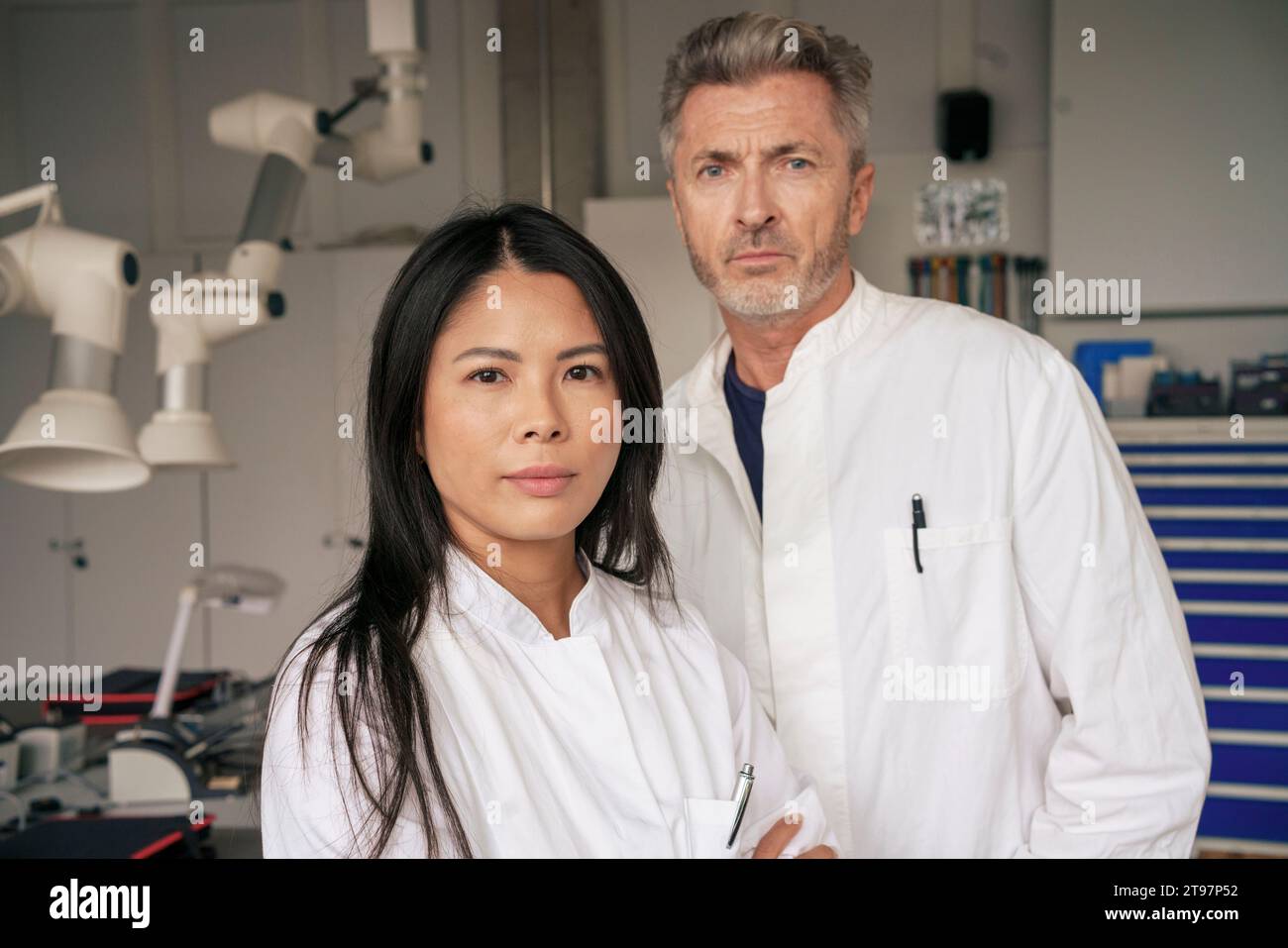 Scientists standing with mature colleague in laboratory Stock Photo - Alamy