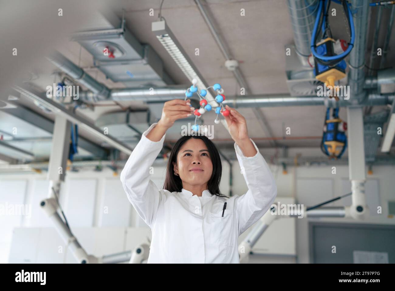 Smiling scientist examining molecular structure at laboratory Stock Photo - Alamy