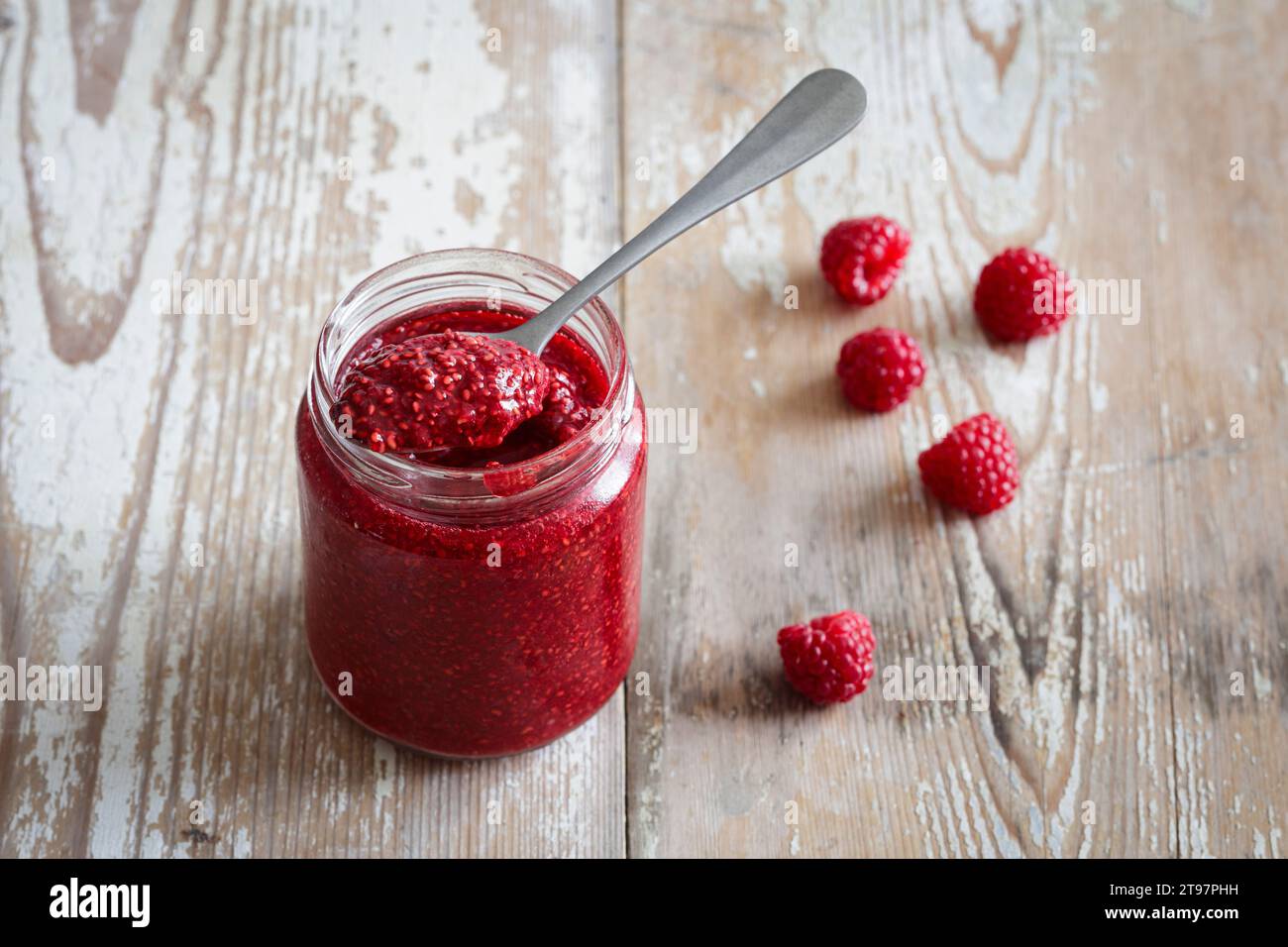 Jar of raspberry jam on wooden surface Stock Photo - Alamy