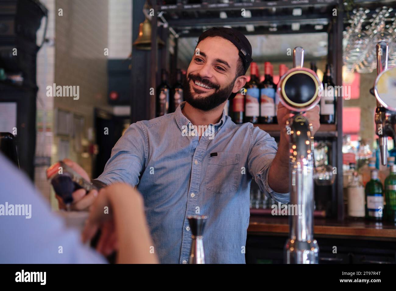 Smiling owner taking order from customer at pub Stock Photo - Alamy