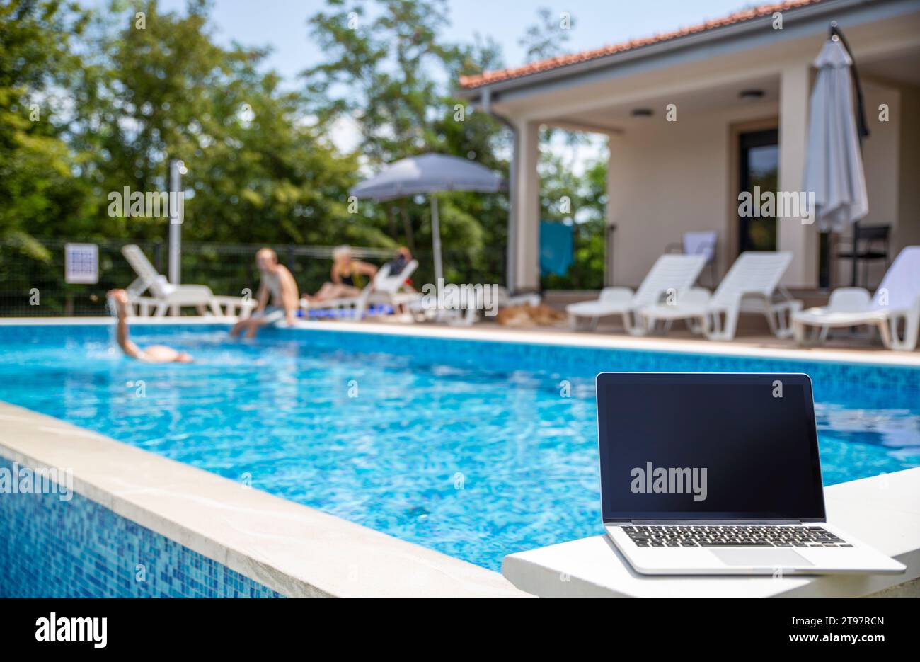 Laptop with blank screen kept near swimming pool on sunny day Stock ...