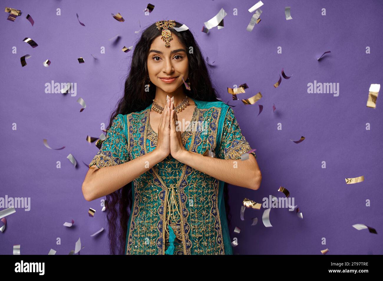 smiley indian woman in blue sari showing praying gesture and looking at ...
