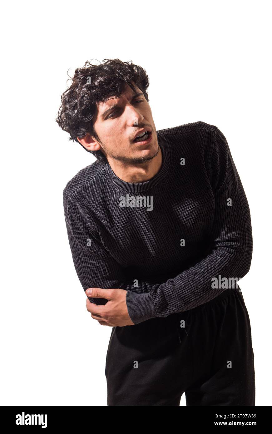 A young man is suffering from belly-ache, stomach ache, in a black ...