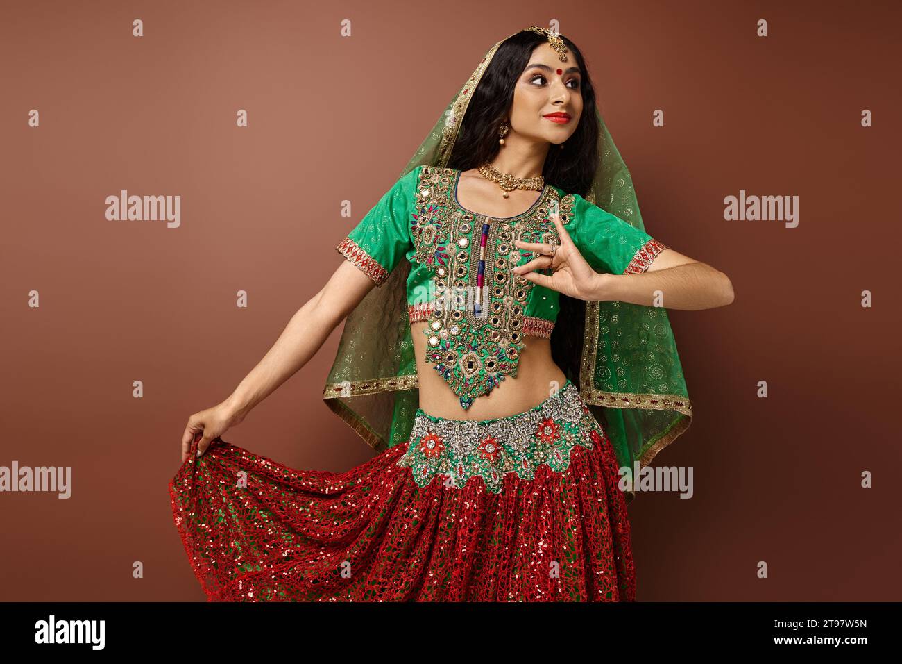 attractive indian woman with bindi in traditional attire gesturing ...