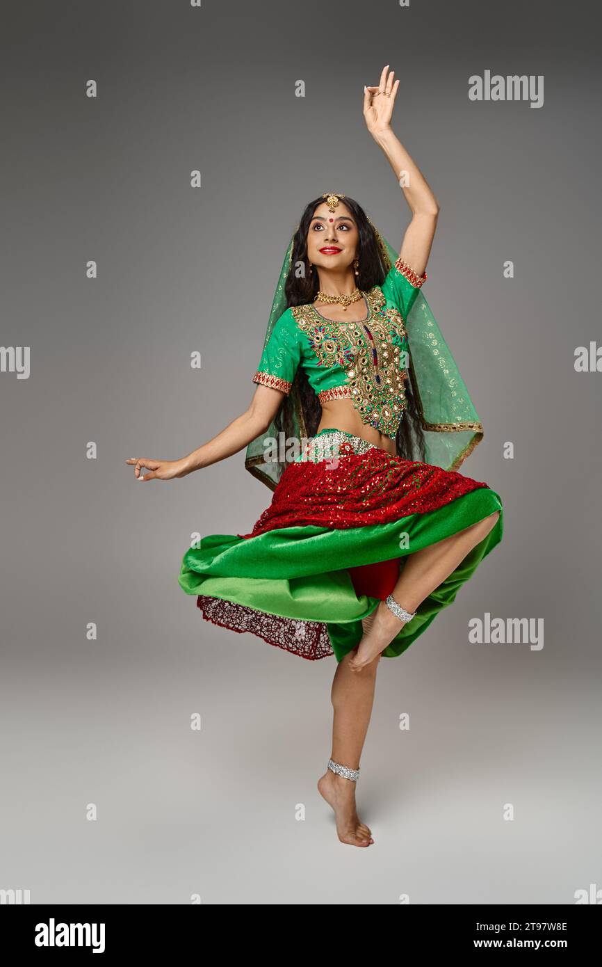 young indian woman in national attire standing on one leg with arm ...