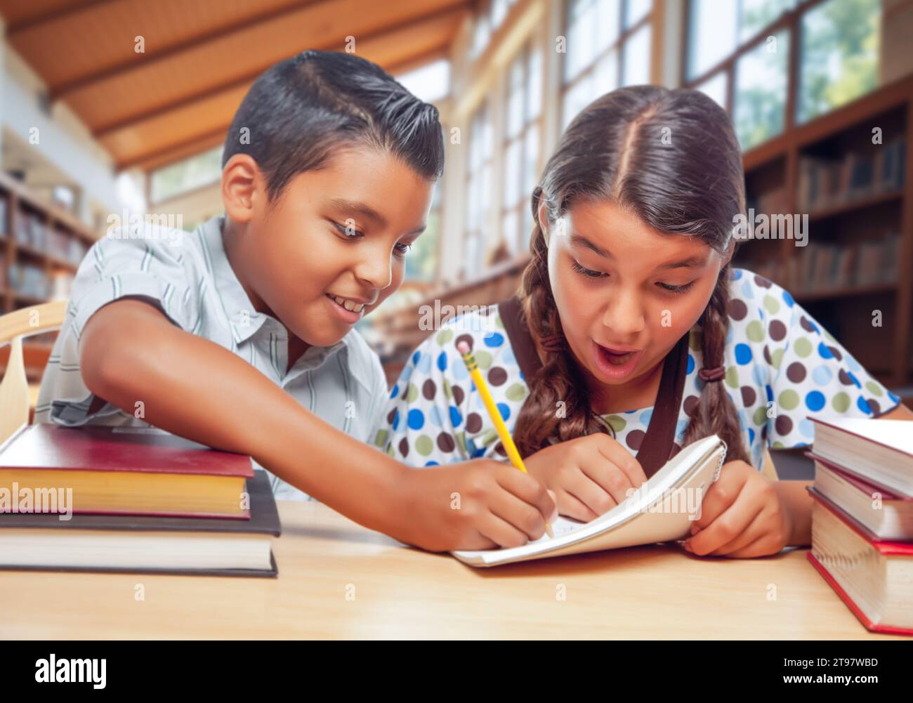 Two Hispanic School Kids in a Library Excited About Their Homework ...