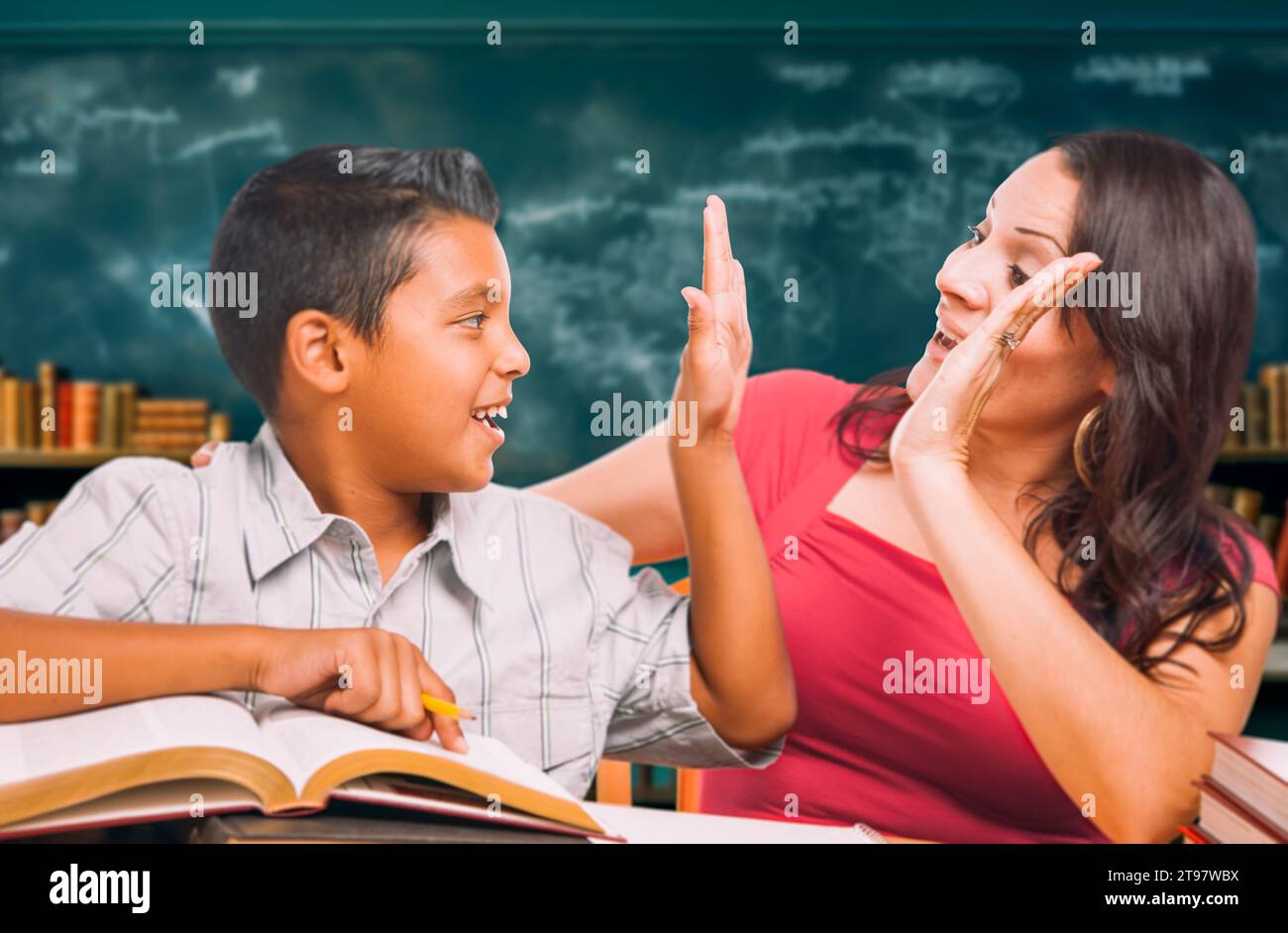 Latina School Teacher High Fiving a Young Hispanic Boy in the Classroom ...