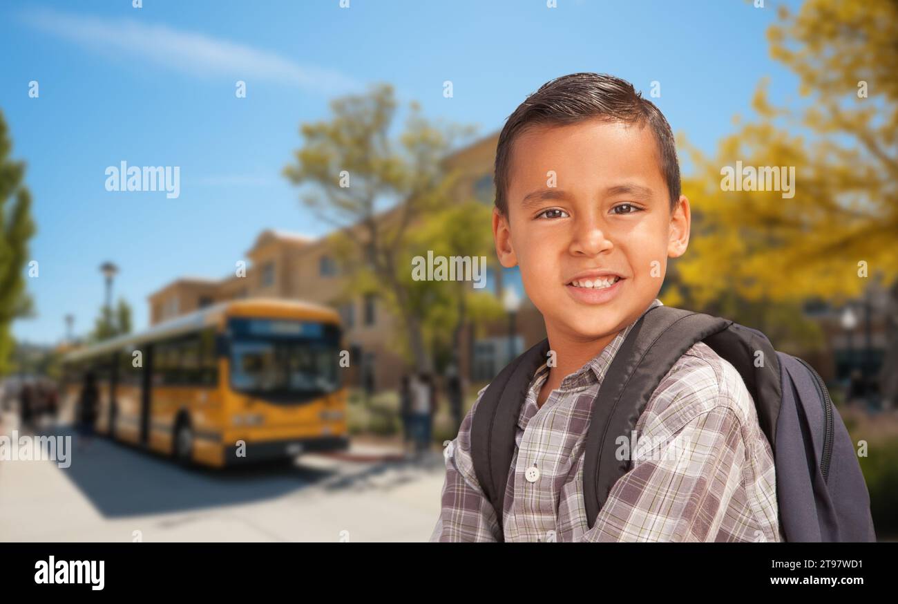 Cute Young Hispanic Boy Wearing a Backpack Near a School Bus on Campus ...