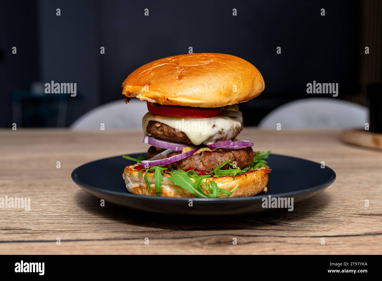 Homemade double hamburger lying on a plate on the dining room table ...