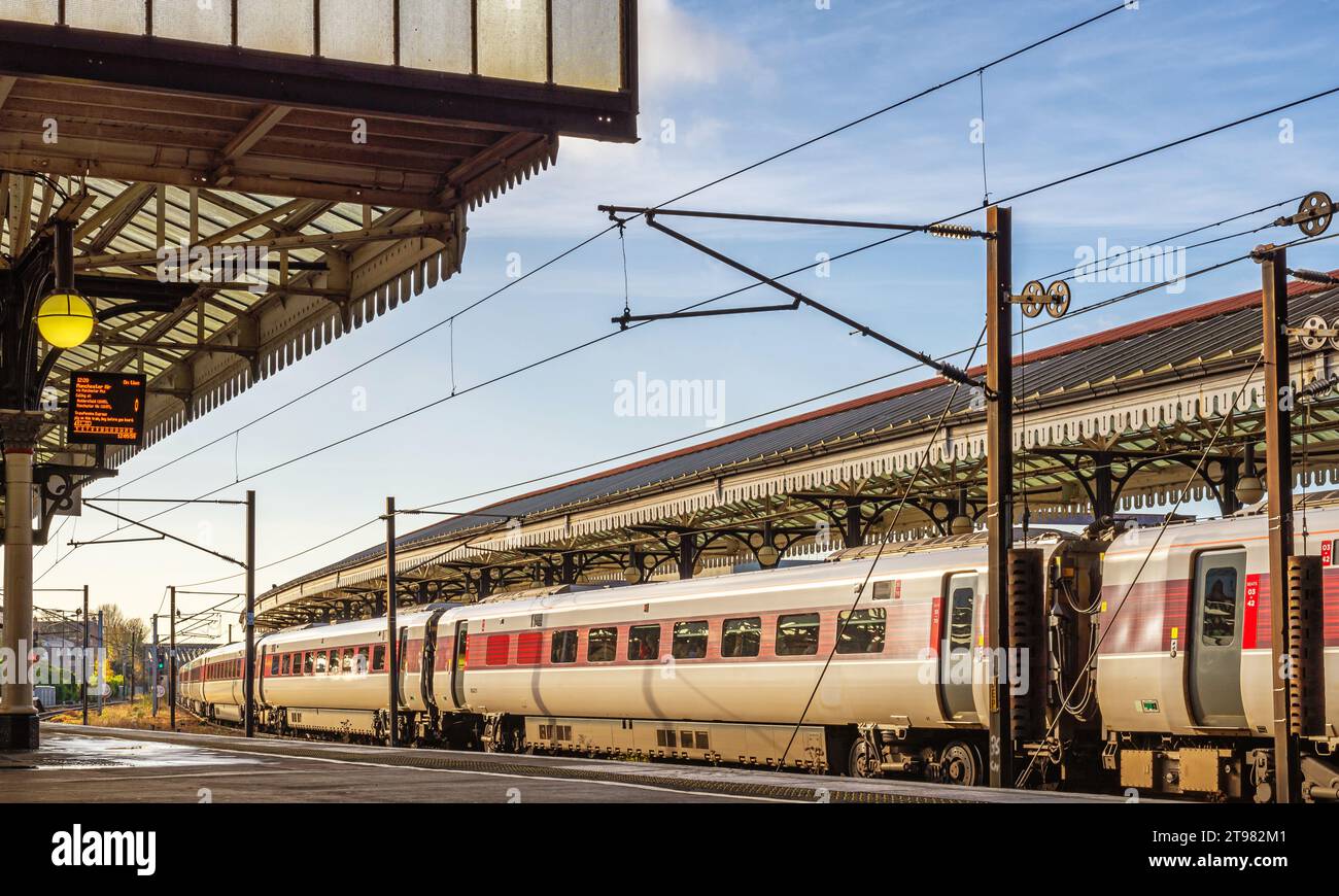 A Railway train bends around a platform into the distance. A historical ...
