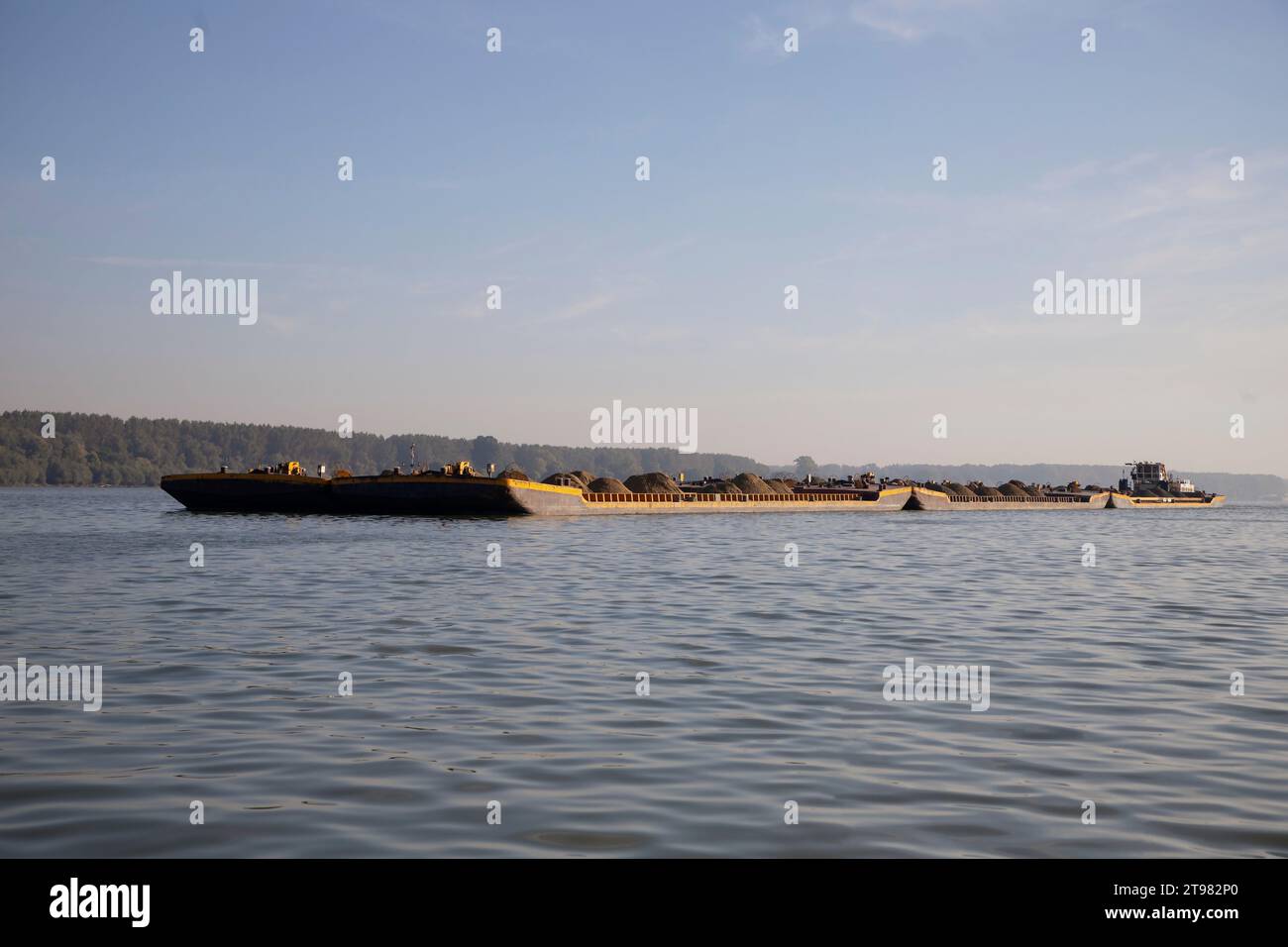 A tugboat pushes combined barges loaded with sand along the Danube ...
