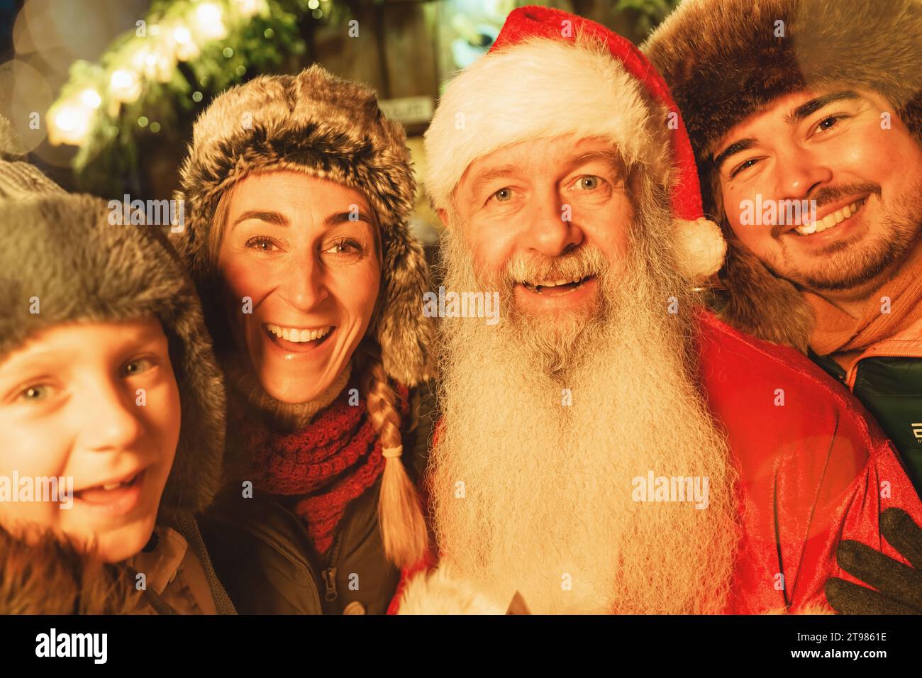 Family and Santa Claus sharing a happy moment at a Christmas market ...