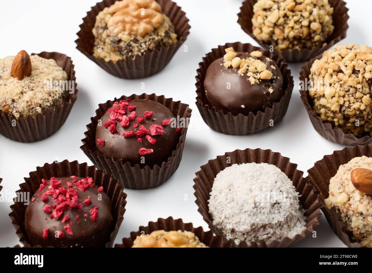 Set of round chocolate candies with nuts on a white background, close ...