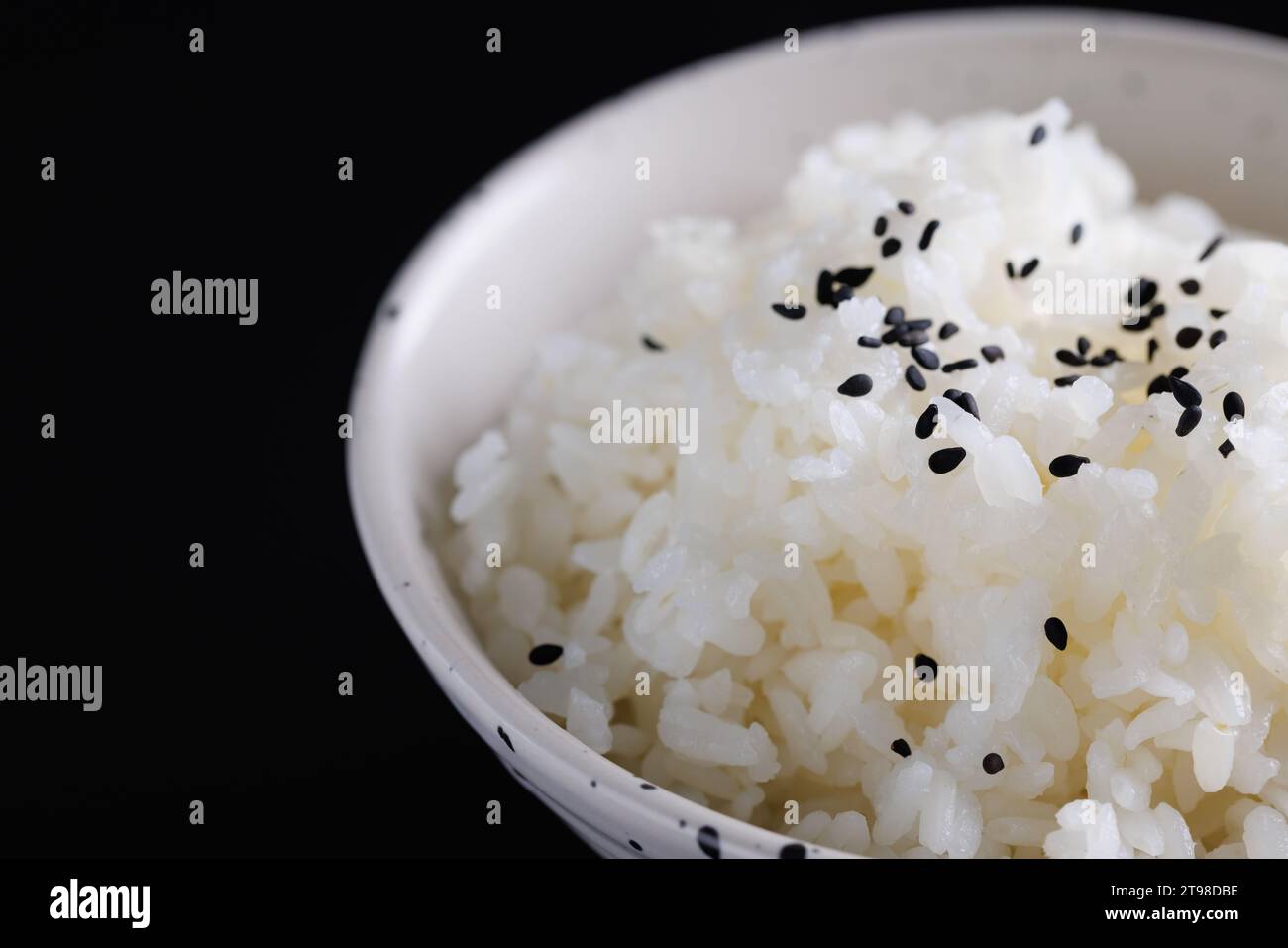 Japanese rice on cup isolated in black background Stock Photo - Alamy