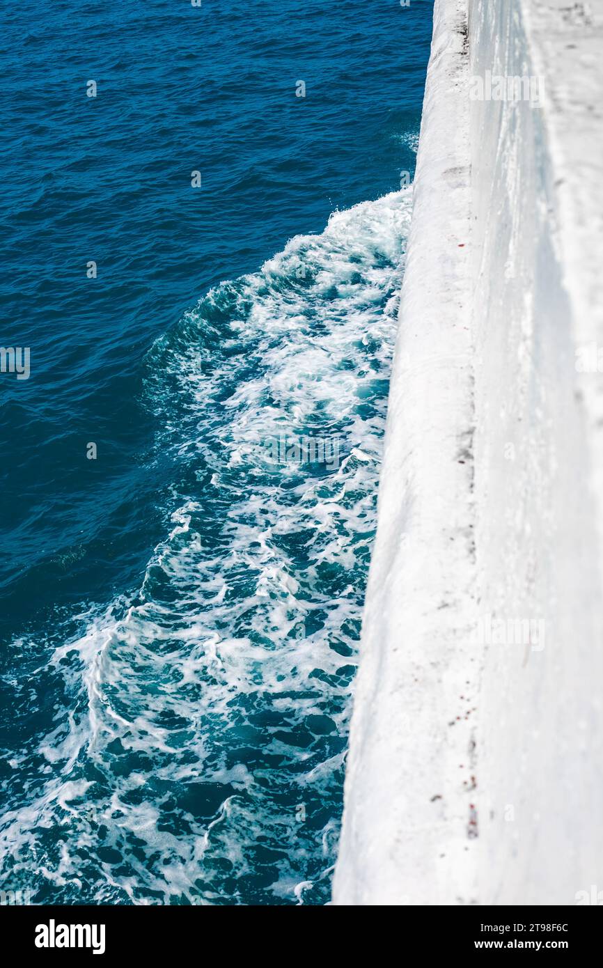 The ship sails on a stormy blue sea, creating waves, as seen from the ...