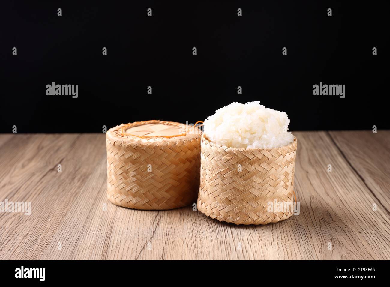 Sticky rice in the small basket with wooden backgrounders isolated in ...