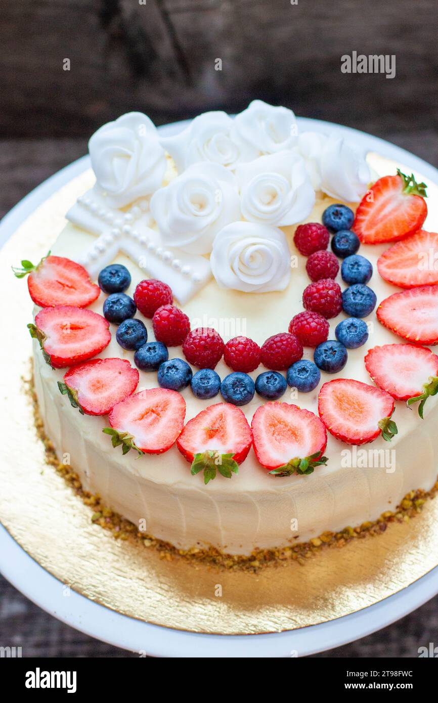 Christening cake for baby. Decoration with fresh berries and fondant flowers. Christening party ...