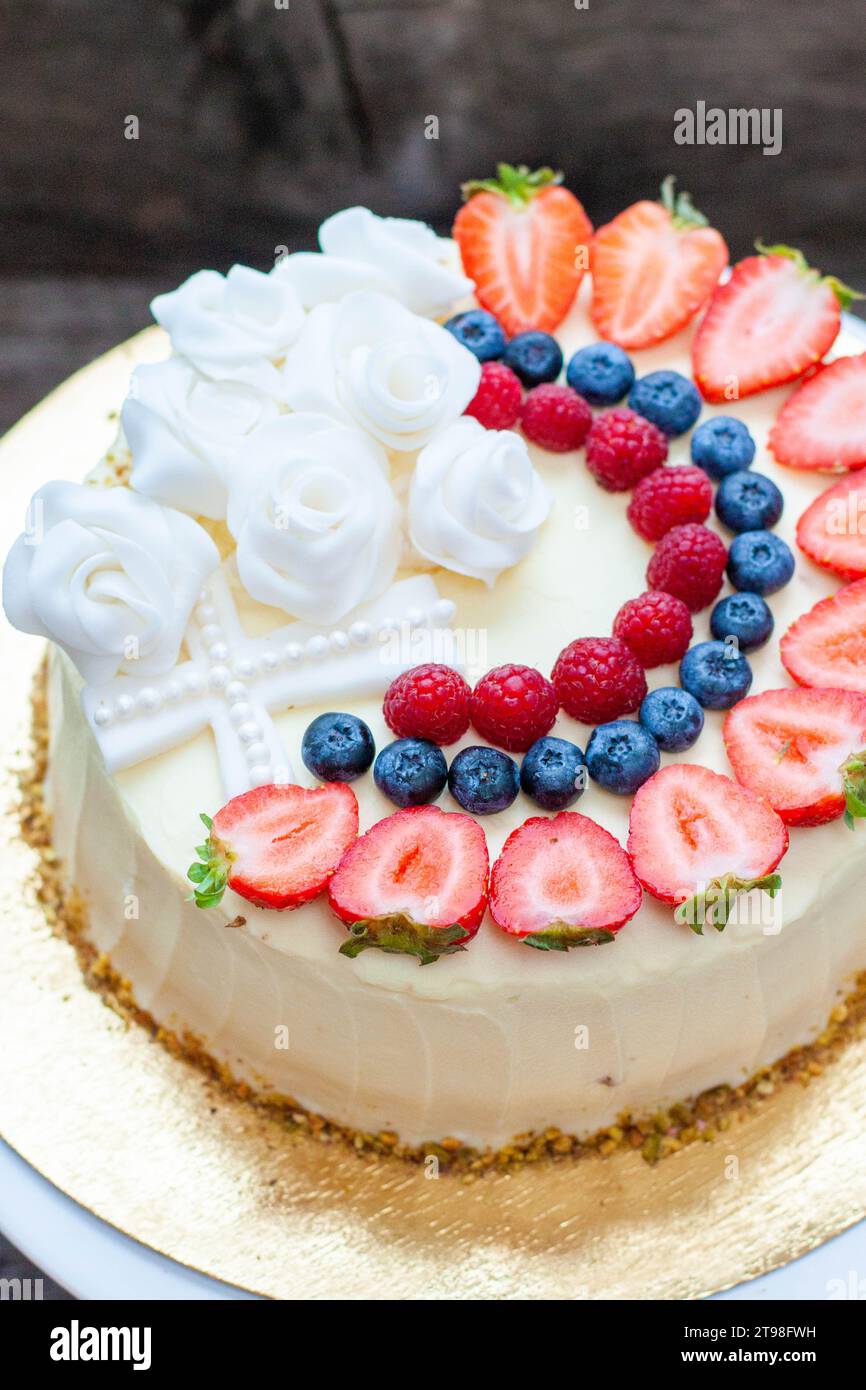 Christening cake for baby. Decoration with fresh berries and fondant flowers. Christening party ...